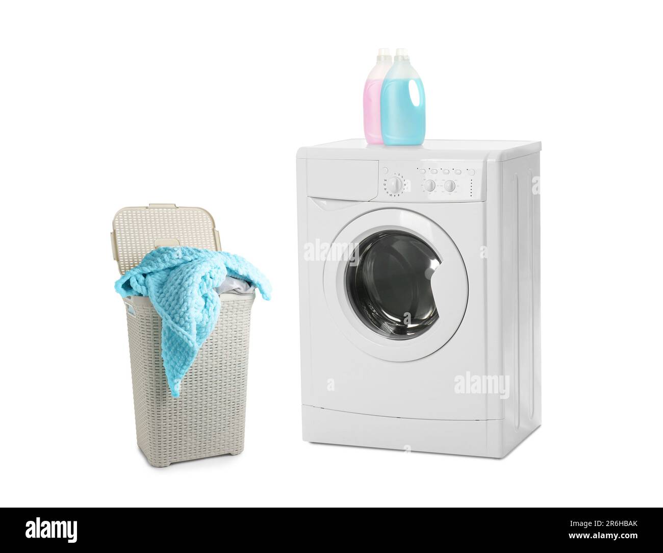 Washing machine, detergents and plastic laundry basket full of clothes ...