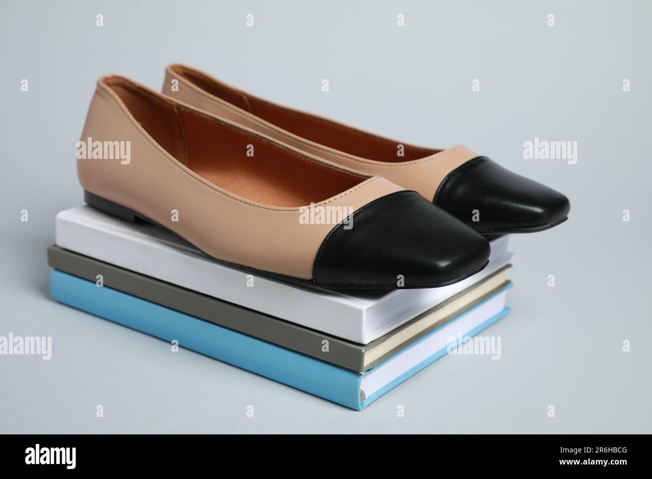 Stack of books with pair of new stylish square toe ballet flats on ...