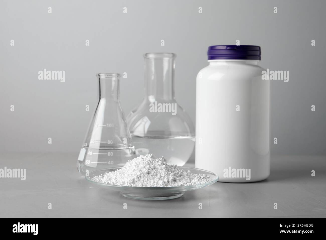 Plate with calcium carbonate powder, jar and laboratory glassware on ...
