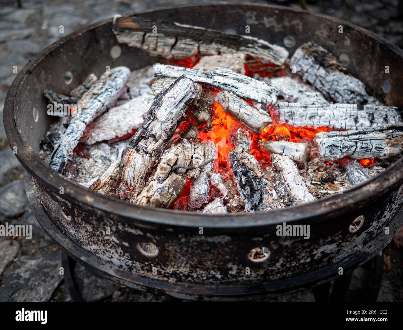 An outdoor brazier with burning firewood emitting heat and smoke Stock ...