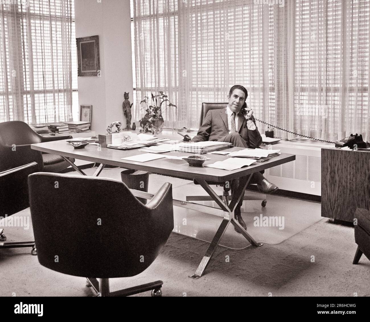 Boss sitting behind desk talking hi-res stock photography and images ...