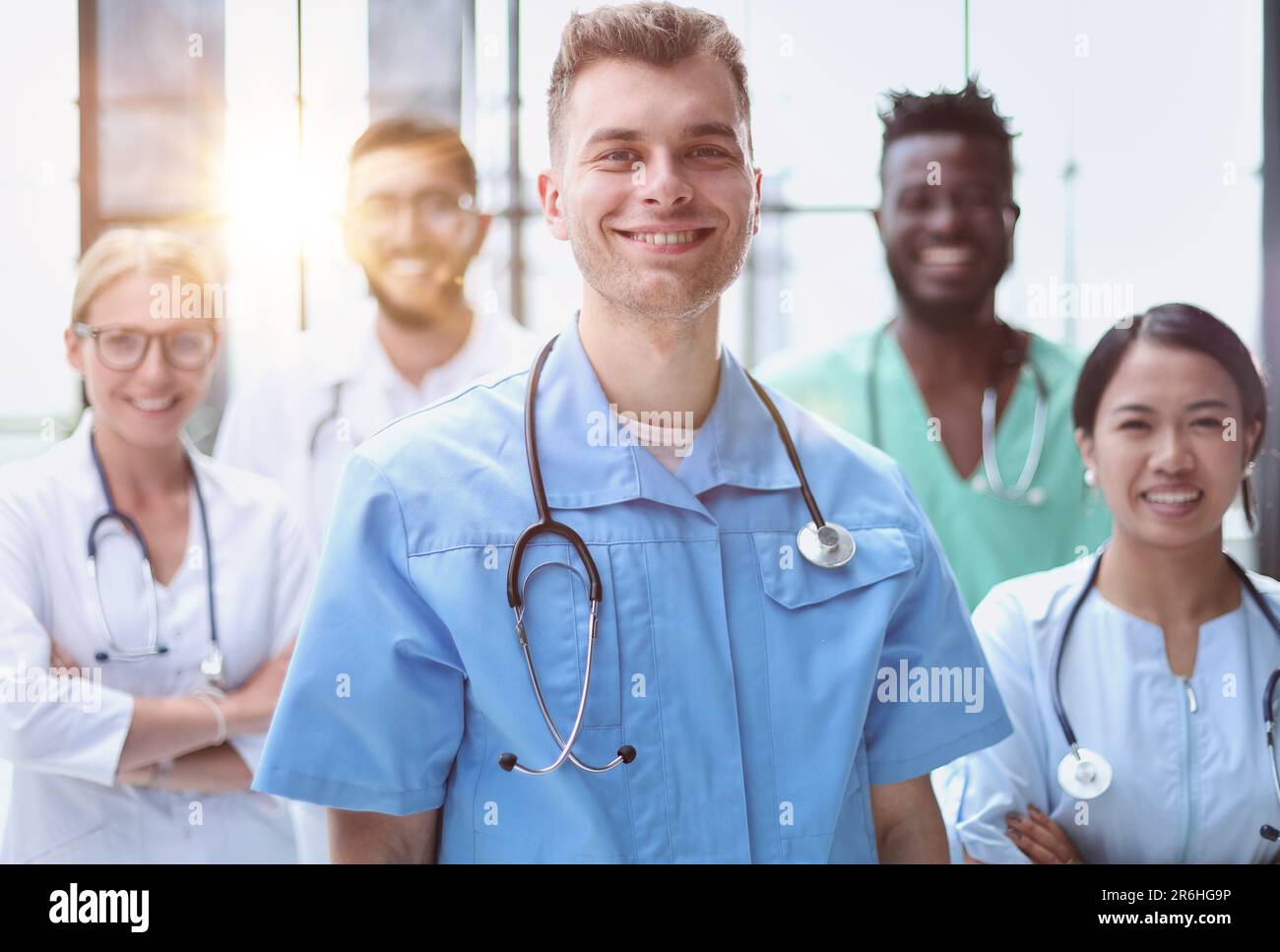 Smiling group of scientists in modern office with male leader, mixed ...