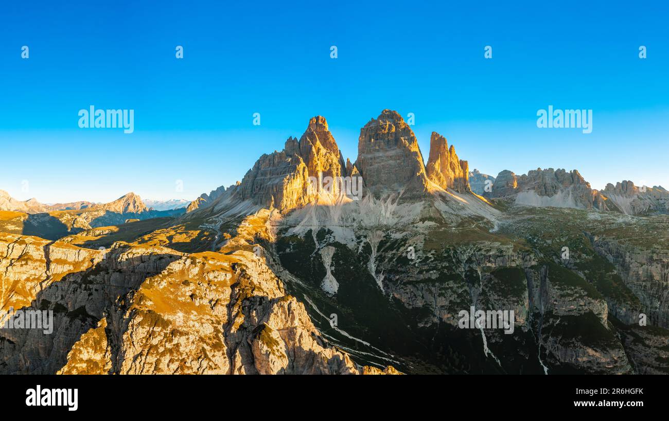 Sun rises over mountain range. High rocky peaks with sand-covered ...