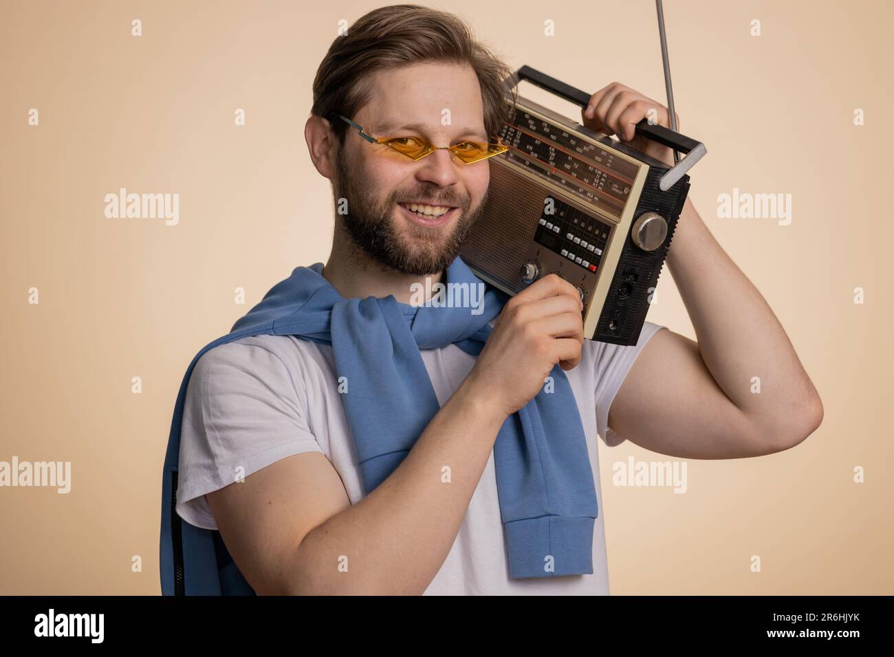 Happy Caucasian man using retro tape record player to listen music ...