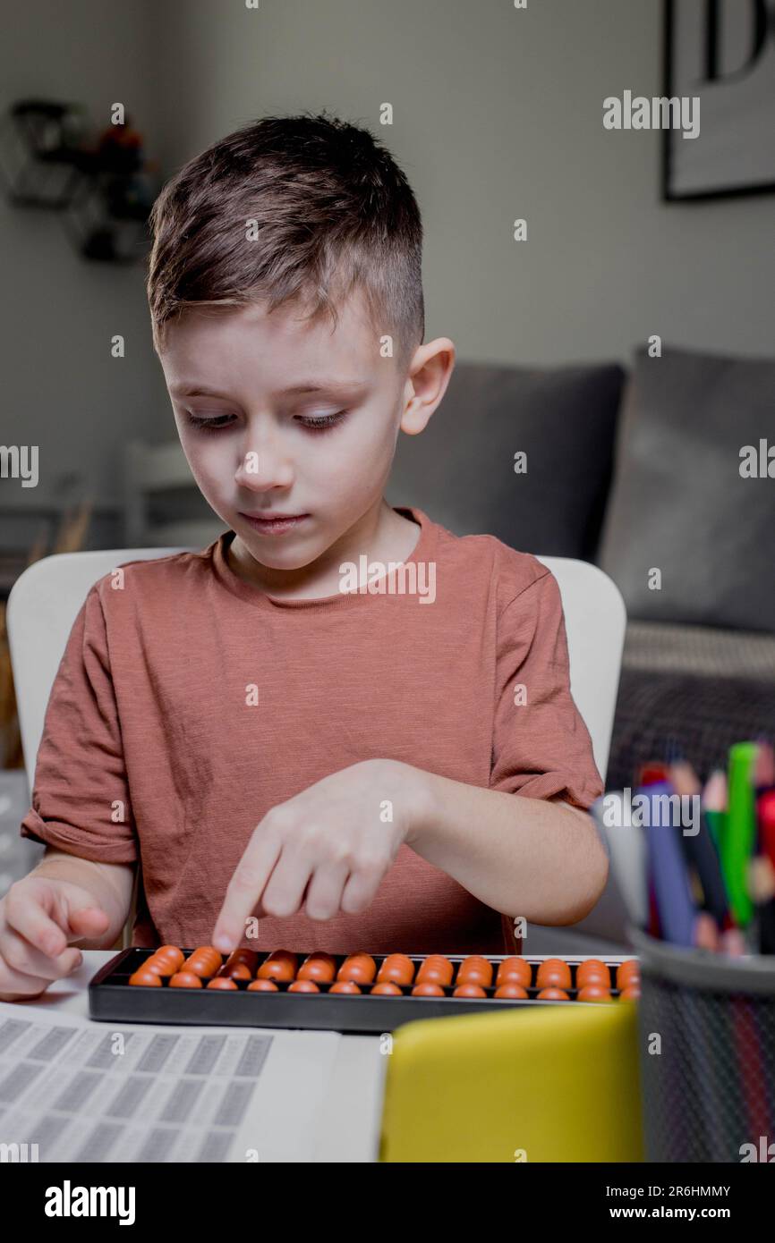Little preschooler counting large numbers on his fingers using mental ...