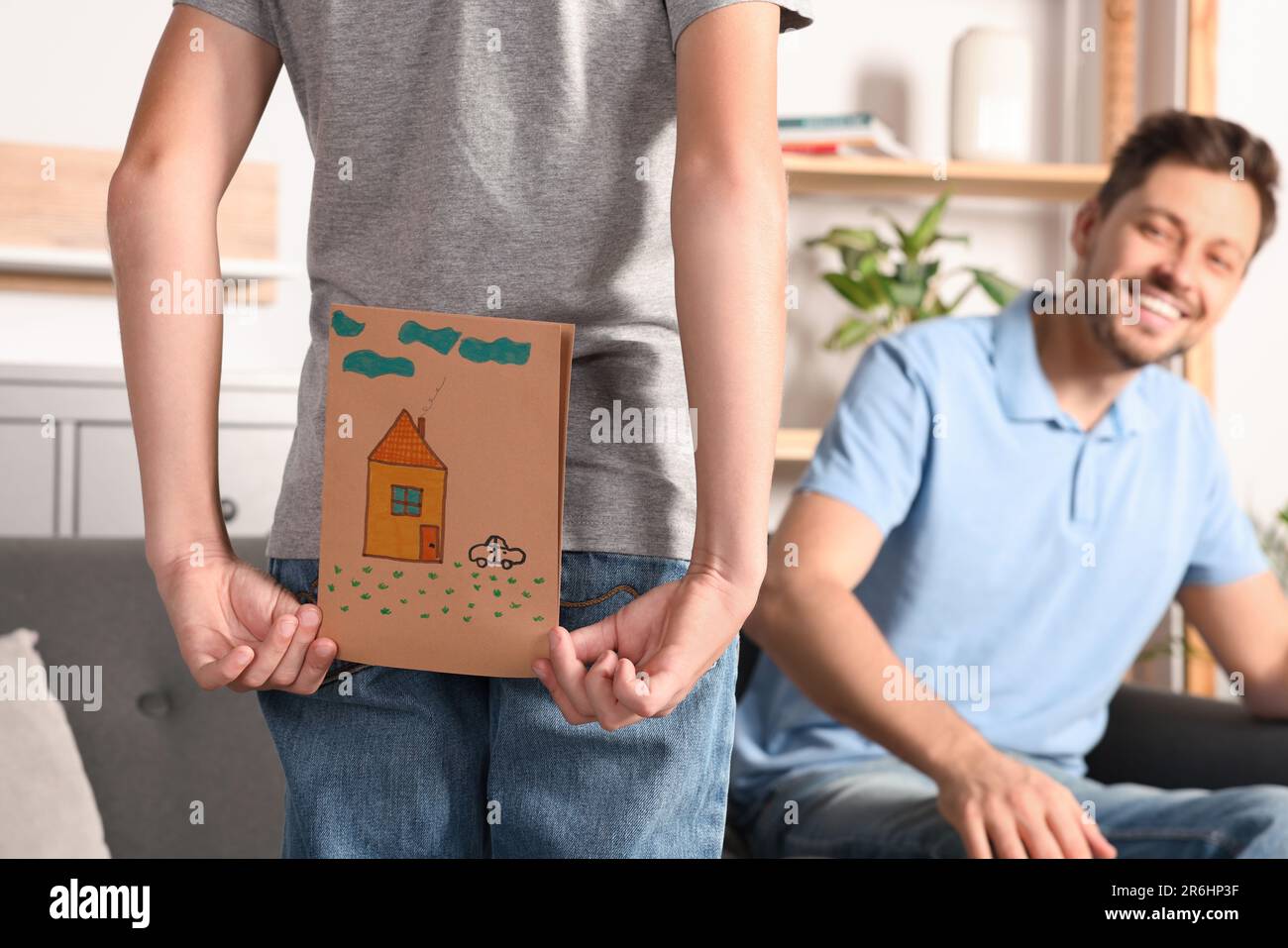 Boy hiding greeting card for his father behind back at home Stock Photo ...