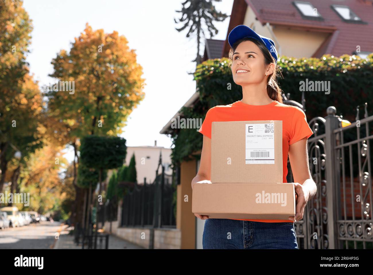 Courier carrying cardboard boxes on city street Stock Photo - Alamy