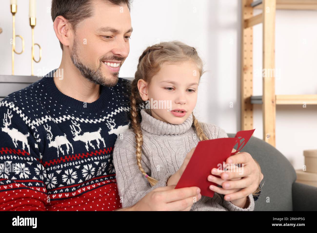 Happy man receiving greeting card from his daughter at home Stock Photo ...