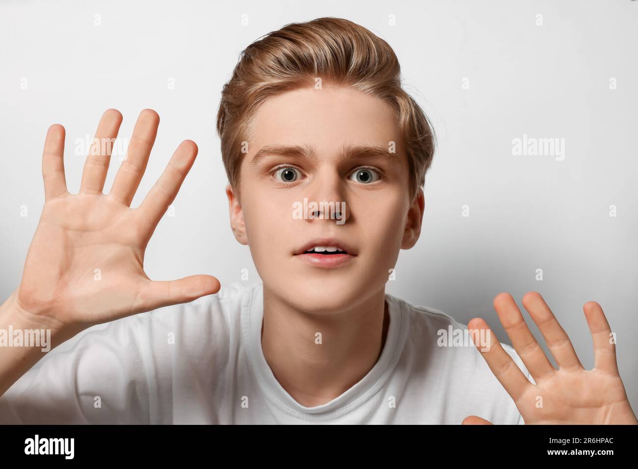 Excited teenage boy stuck to transparent screen Stock Photo - Alamy
