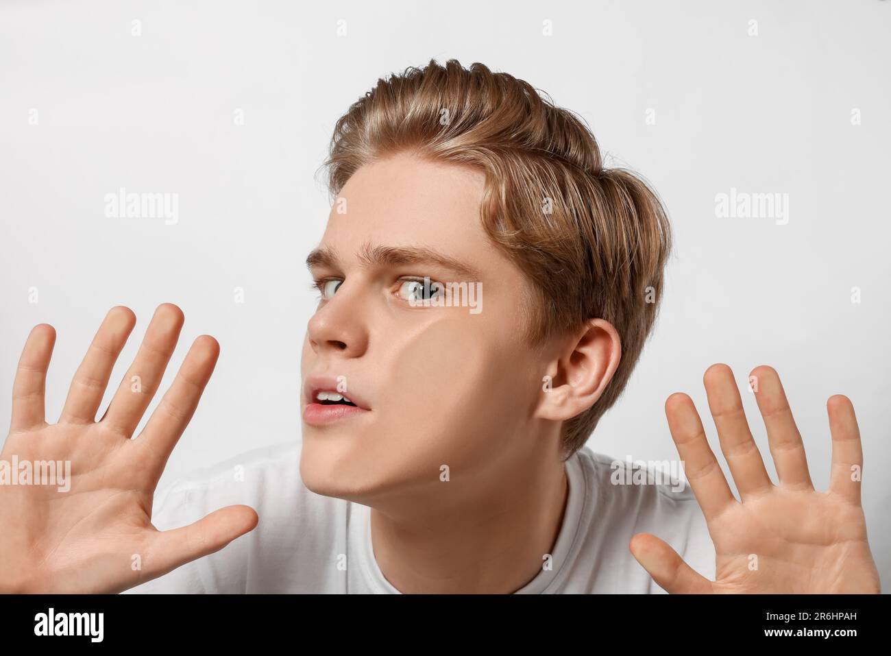 Shocked teenage boy stuck to transparent screen Stock Photo - Alamy