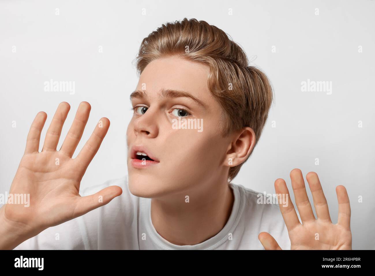 Shocked teenage boy stuck to transparent screen Stock Photo - Alamy