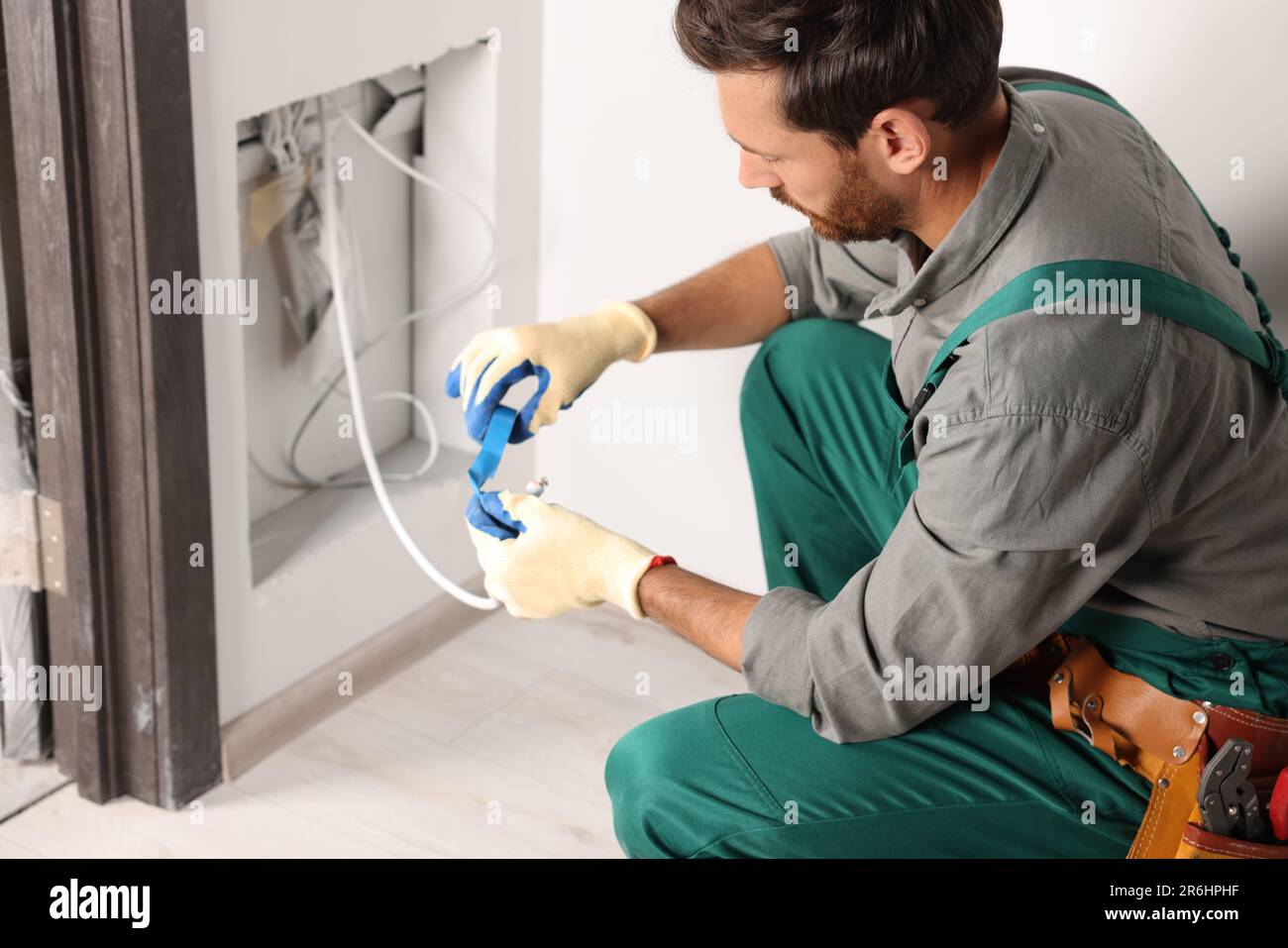 Electrician fixing wires with insulating tape indoors Stock Photo - Alamy