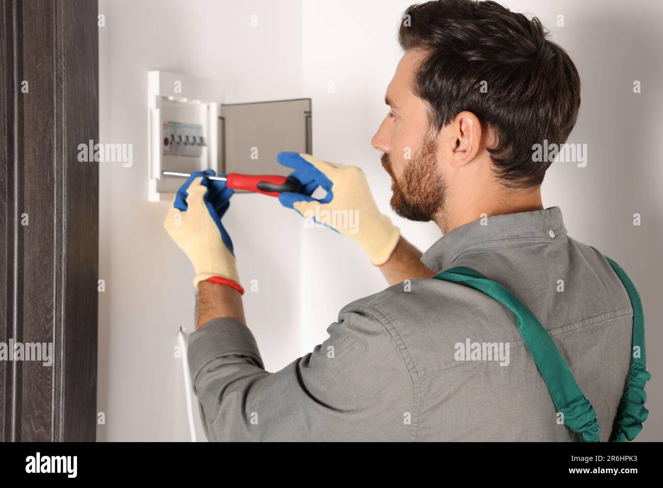 Electrician installing fuse box with screwdriver indoors Stock Photo ...