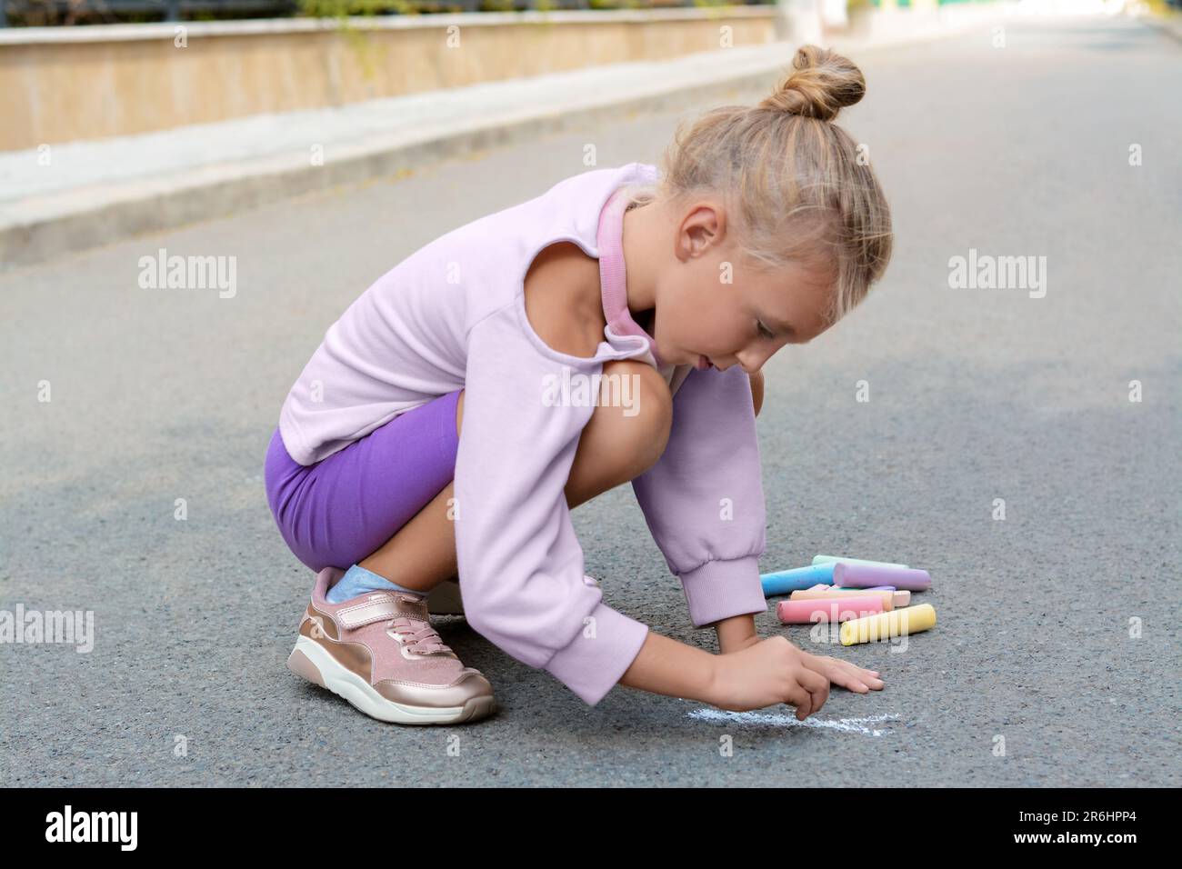 Little child drawing butterfly with chalk on asphalt Stock Photo - Alamy