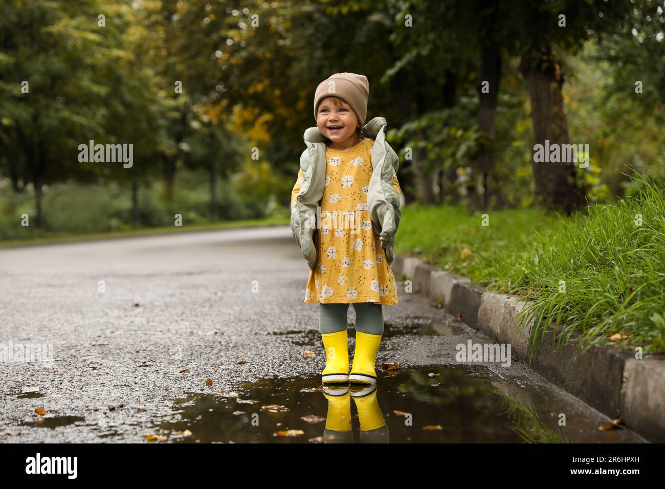 Cute little girl standing in puddle outdoors Stock Photo - Alamy
