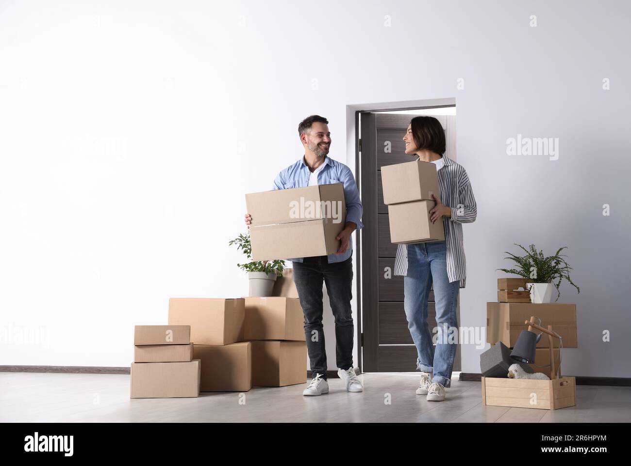 Happy couple with moving boxes entering in new apartment Stock Photo ...