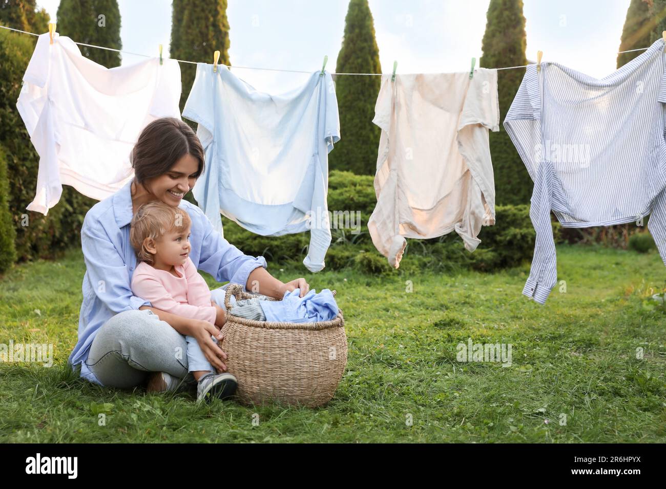 Mother and daughter near washing line with drying clothes in backyard Stock Photo - Alamy