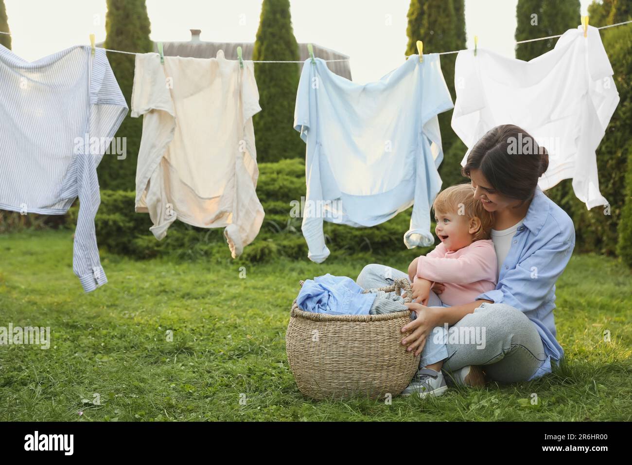 Mother and daughter near washing line with drying clothes in backyard ...