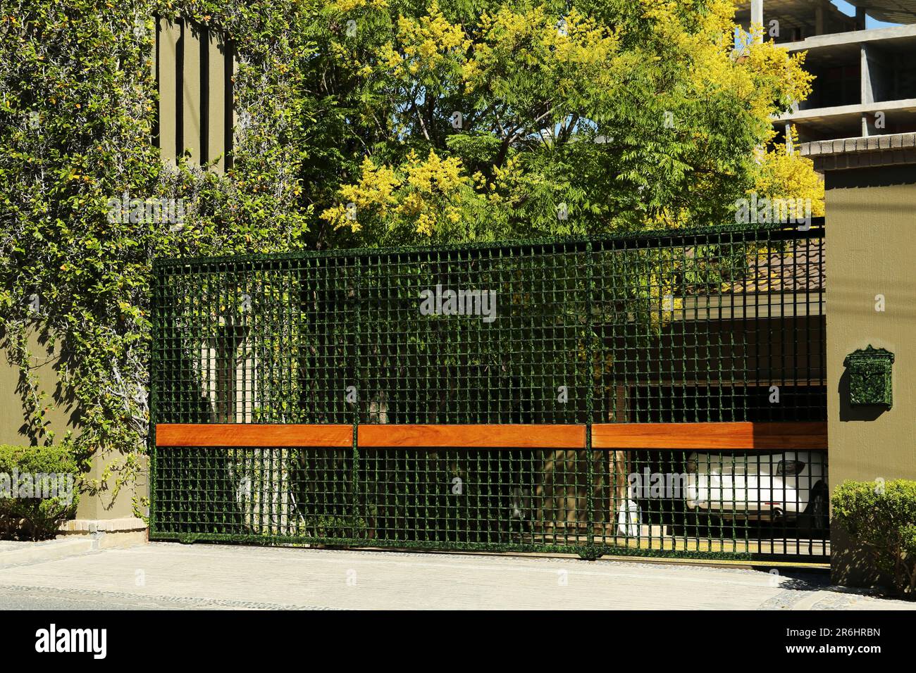 Security metal gates near trees and estate outdoors Stock Photo - Alamy