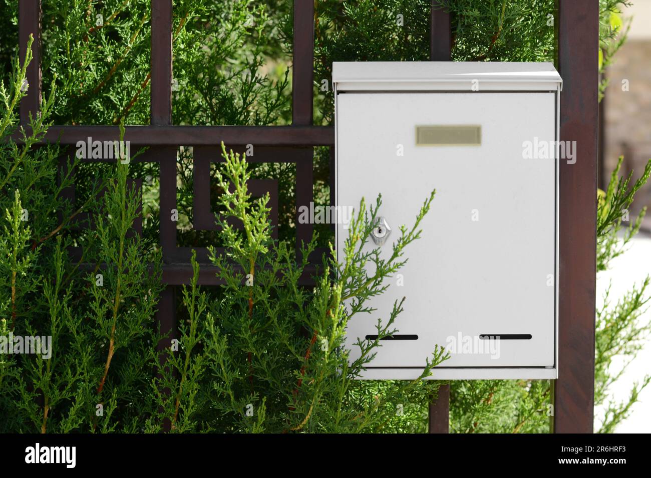 White metal letter box on fence near tree outdoors Stock Photo - Alamy