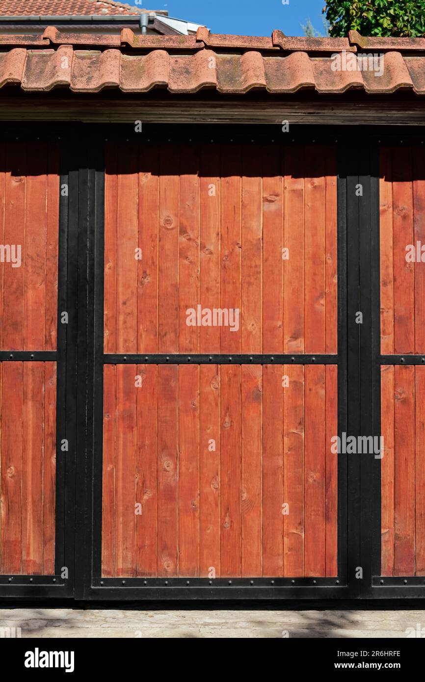 Metal and wooden fence with roof outdoors Stock Photo - Alamy