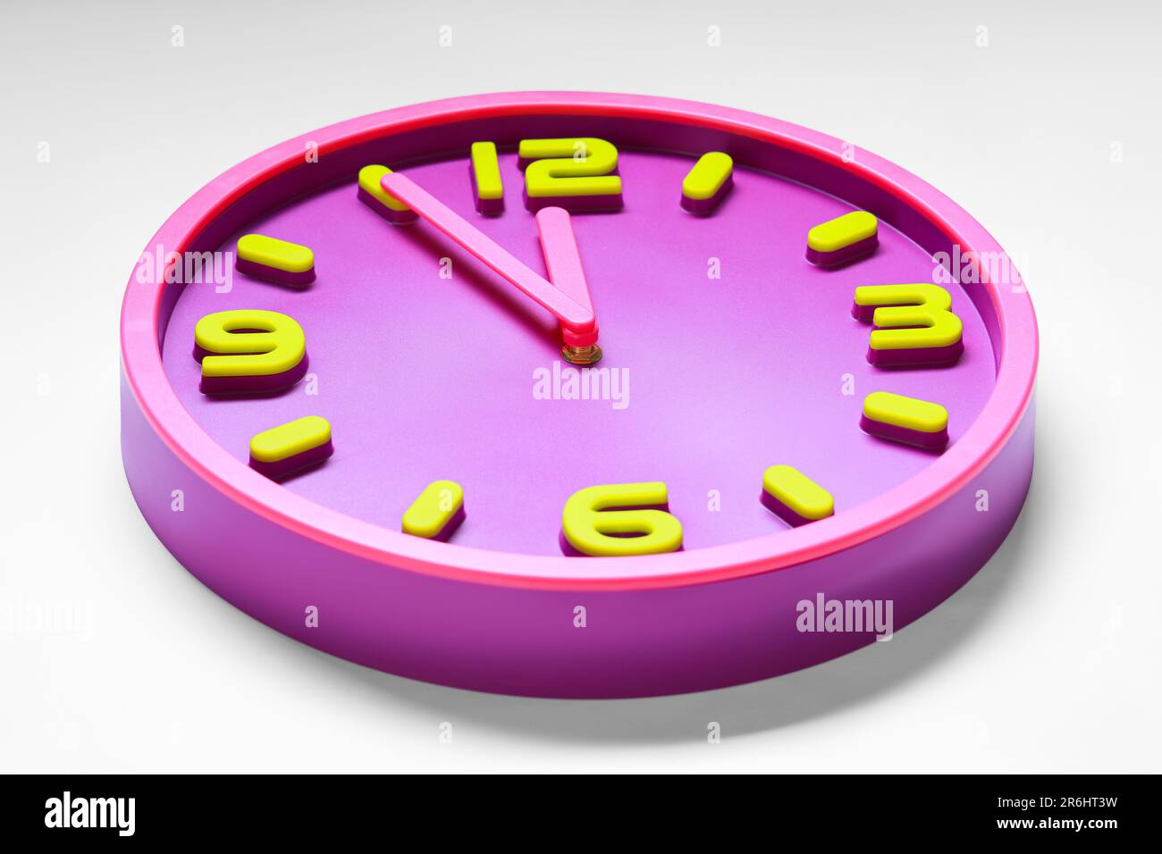 Clock showing five minutes until midnight on white background, closeup ...