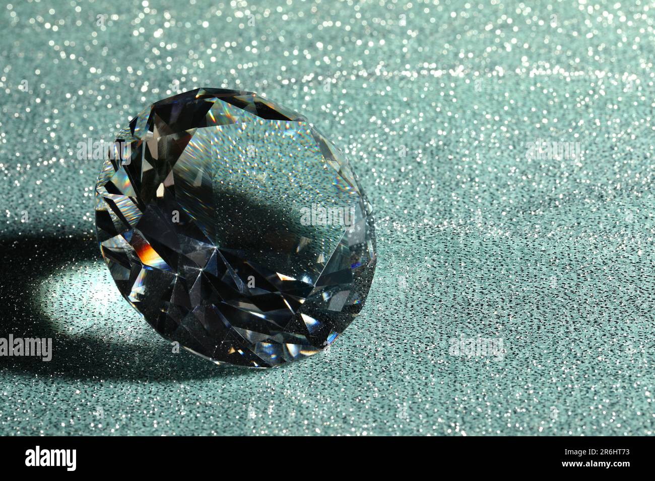 Beautiful dazzling diamond on silver glitter background, closeup. Space ...