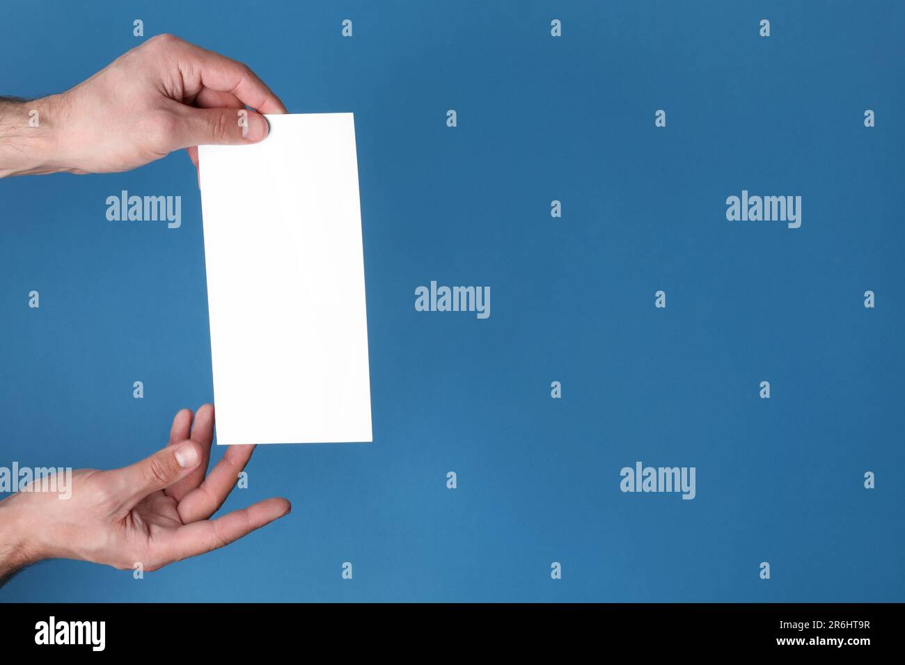 Man holding flyer on blue background, closeup. Mockup for design Stock ...