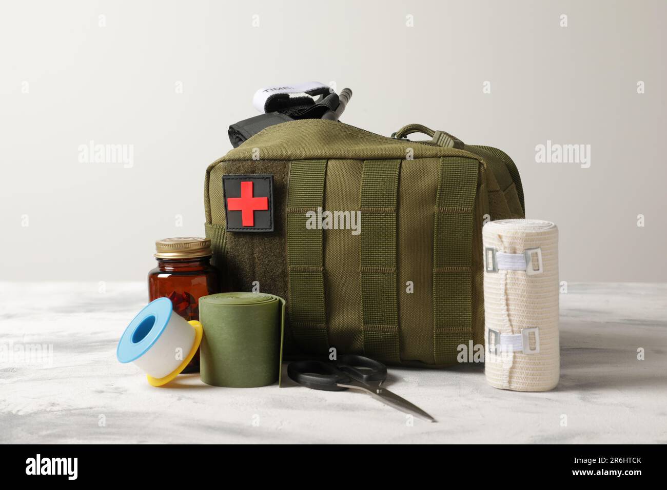 Military first aid kit, tourniquet, pills and elastic bandage on light ...