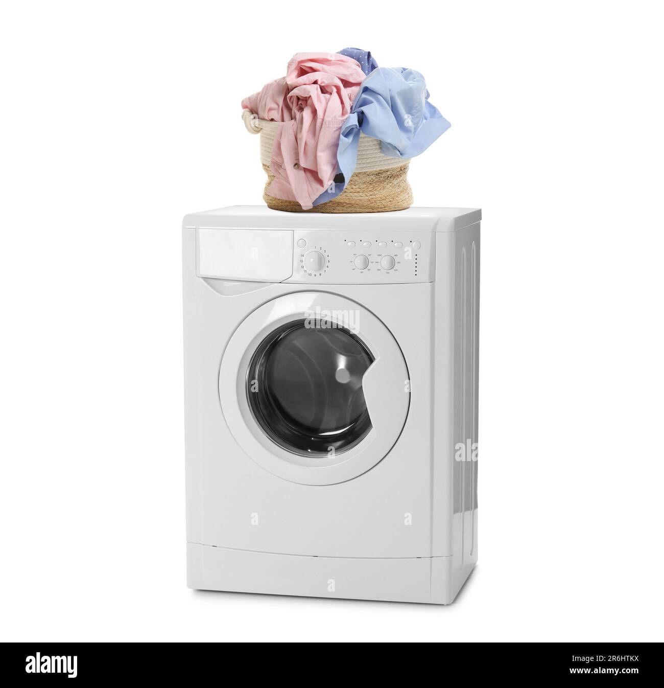 Washing machine and wicker laundry basket full of clothes on white ...