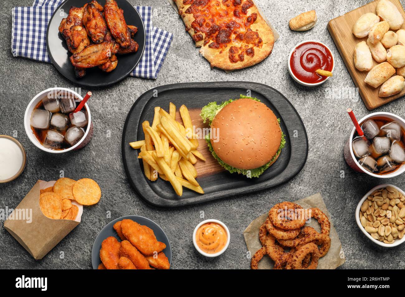 French fries, burger and other fast food on gray textured table, flat ...