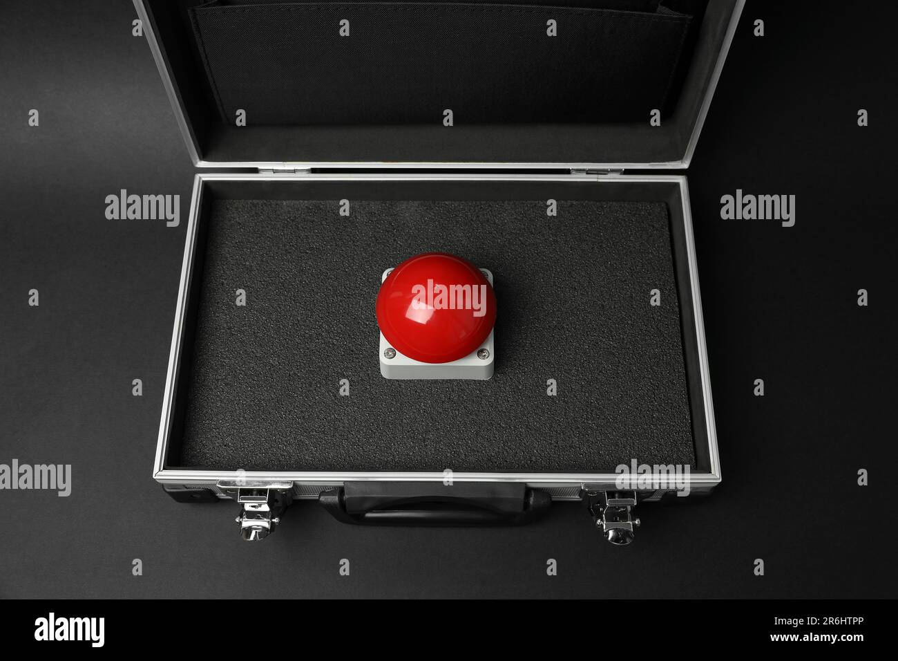 Red button of nuclear weapon in suitcase on black background, above ...