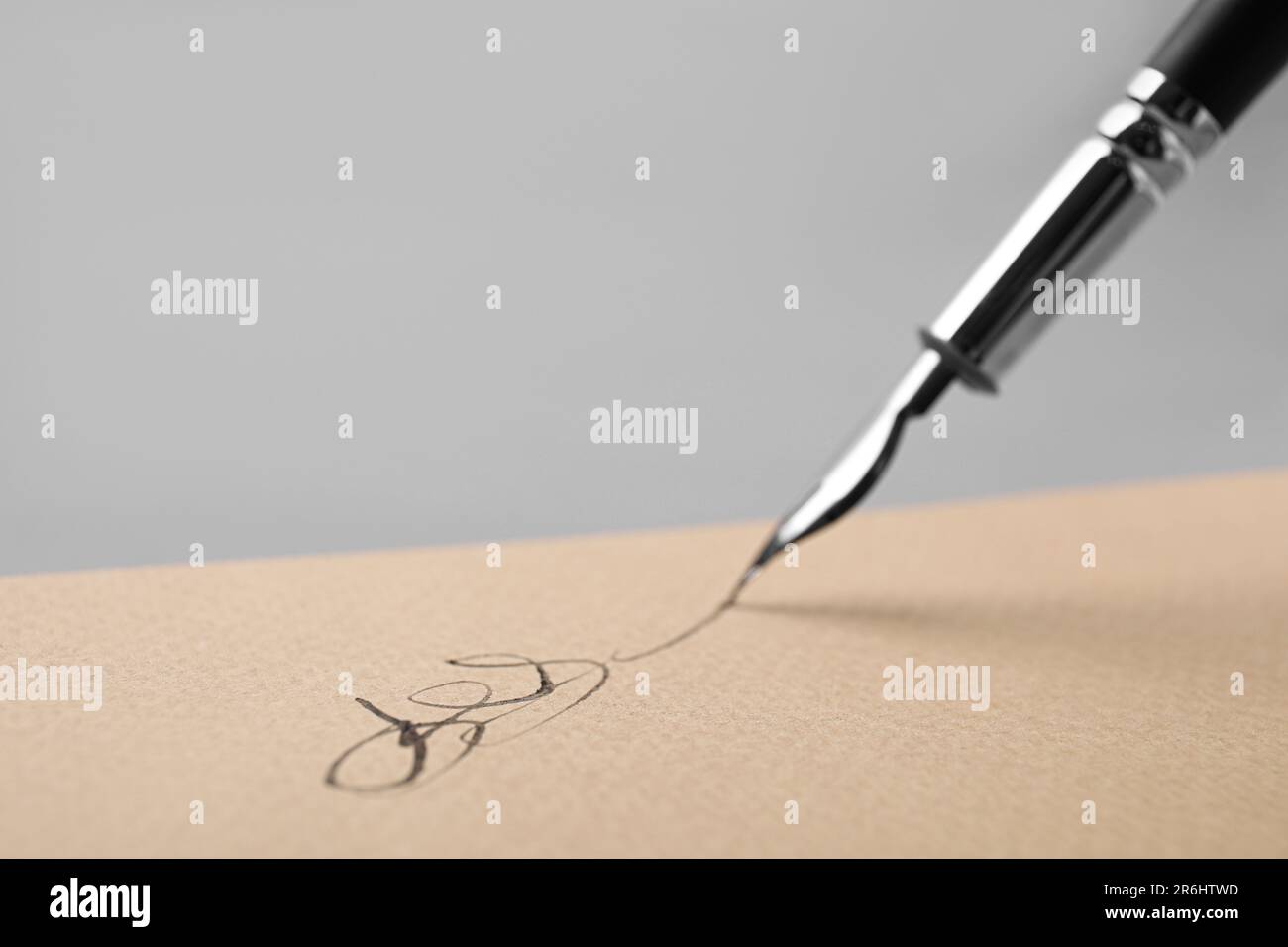 Signing on sheet of paper with fountain pen, closeup. Space for text ...