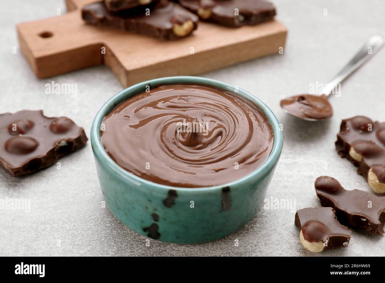 Chocolate pieces and bowl of sweet paste on grey table Stock Photo - Alamy
