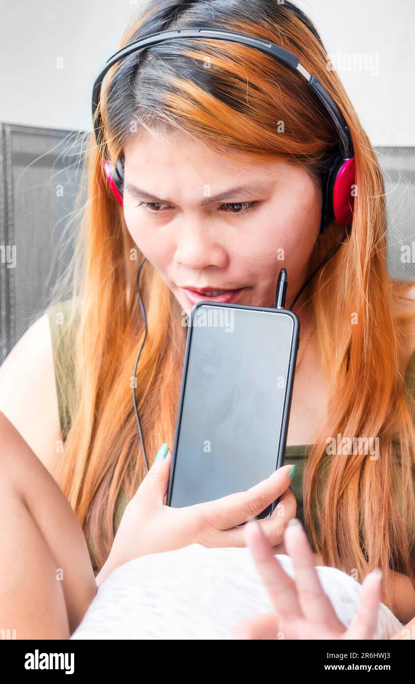 Sitting outside, on a high rise condo building balcony,wearing ...