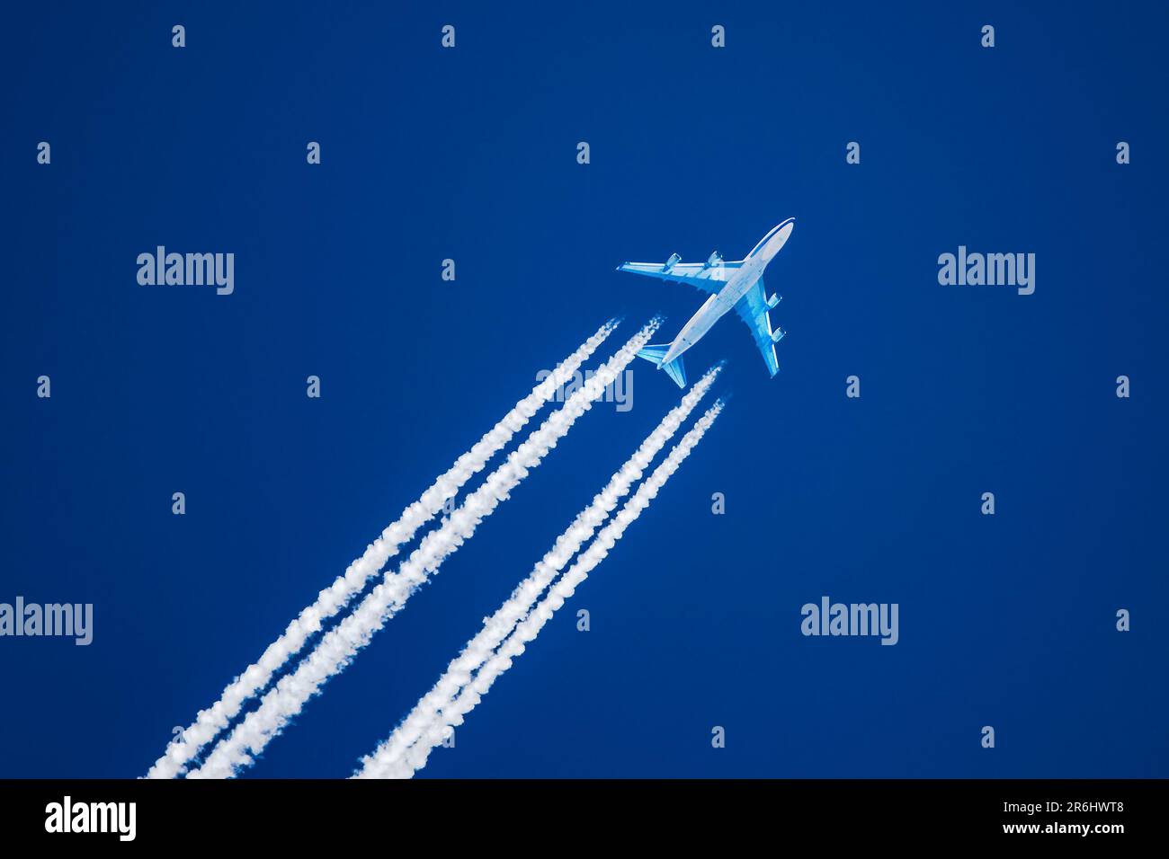 Sharp telephoto close-up of jet plane aircraft with contrails cruising ...