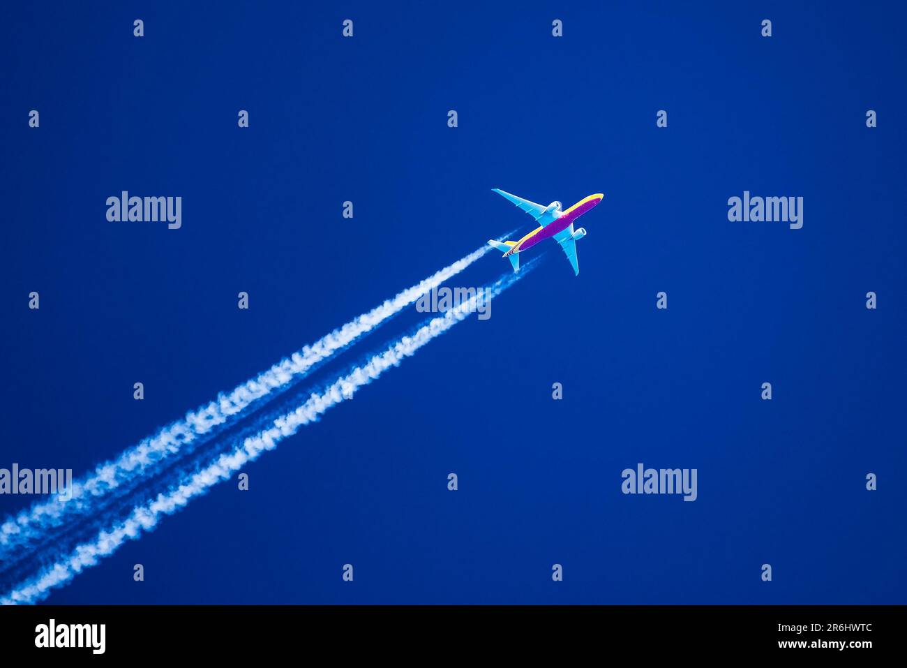Sharp telephoto close-up of jet plane aircraft with contrails cruising ...