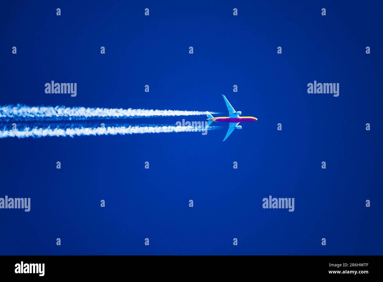 Sharp telephoto close-up of jet plane aircraft with contrails cruising ...