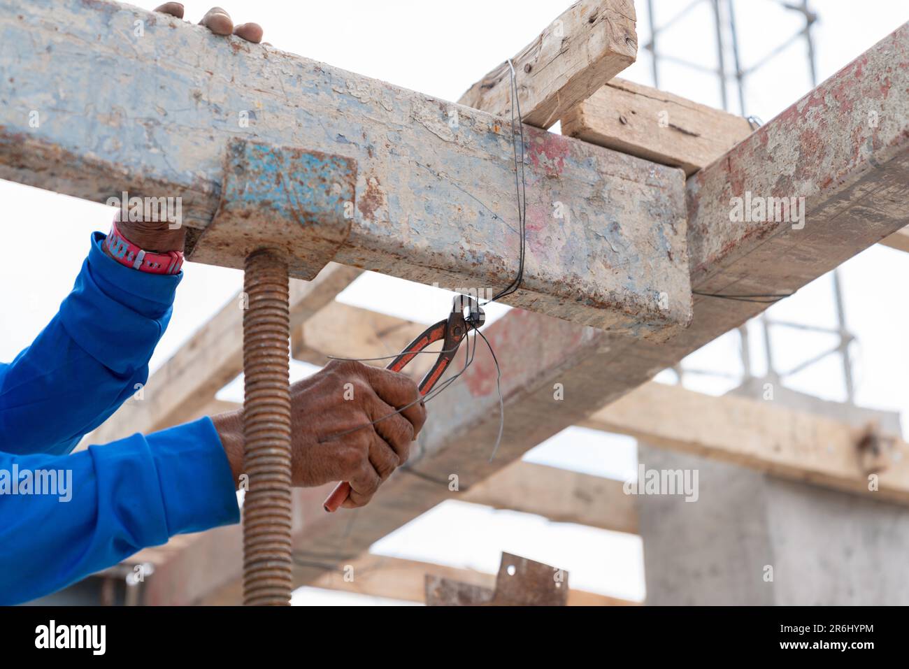 Workers use scaffolding wire to support the floor pouring concrete in ...