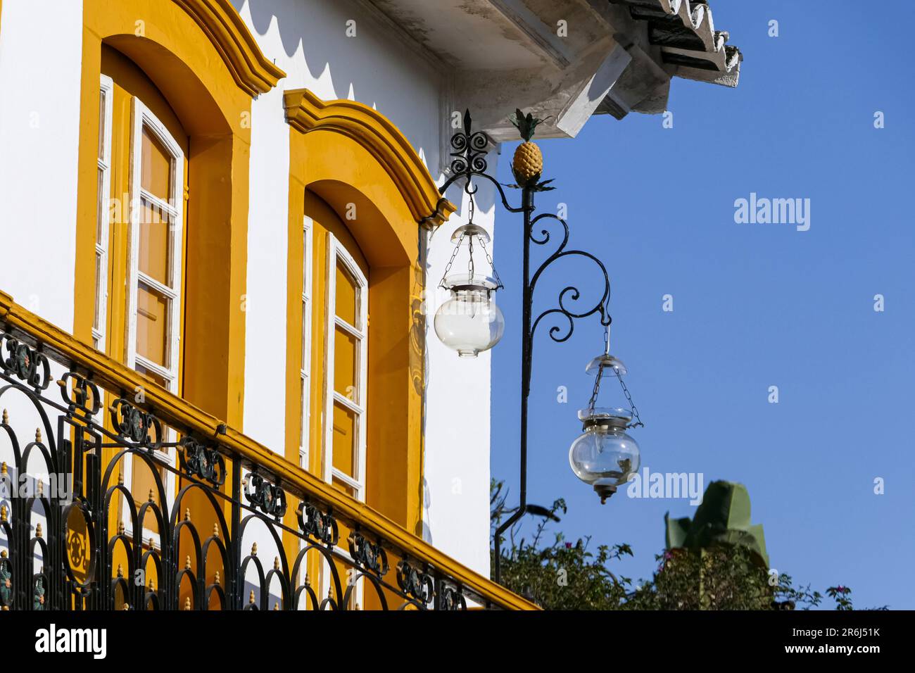 Close-up of an artful colonial house corner with two yellow framed high ...