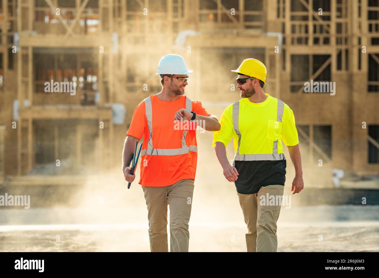 Two builders in a hard hat is busy working on a construction project at ...