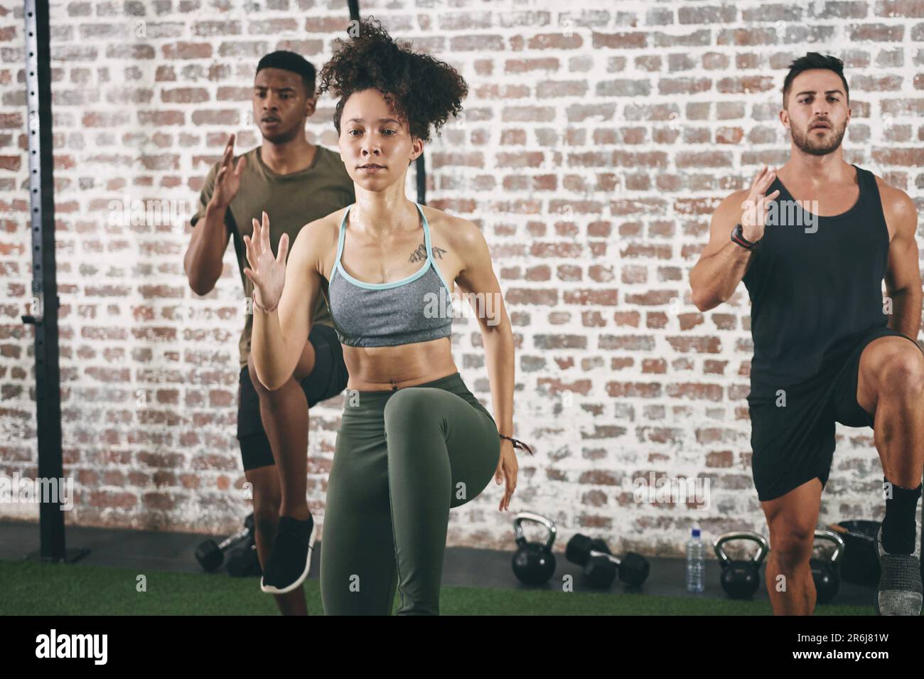 Try something new with group fitness. a fitness group doing high knees ...