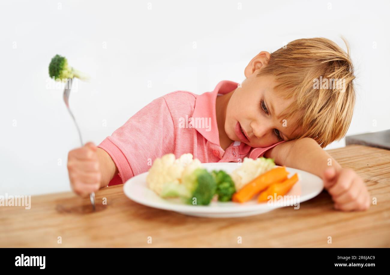 Sad, diet and a child with vegetables for dinner, unhappy meal and ...