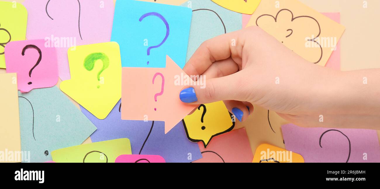 Female hand and many sticky papers with question marks, closeup Stock ...