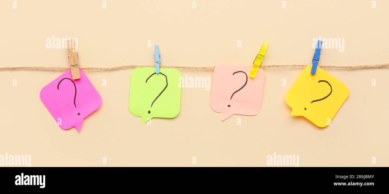 Paper sticks with question marks on rope against beige background Stock ...