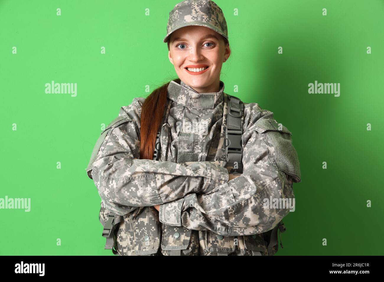 Female soldier in military uniform on green background Stock Photo - Alamy