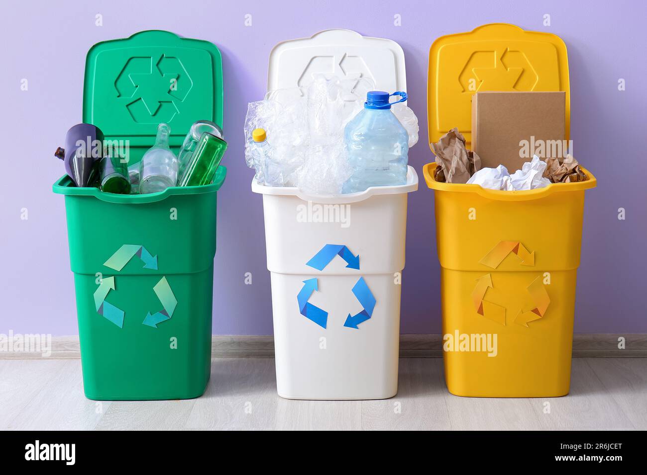 Containers with different types of garbage near lilac wall. Recycling ...