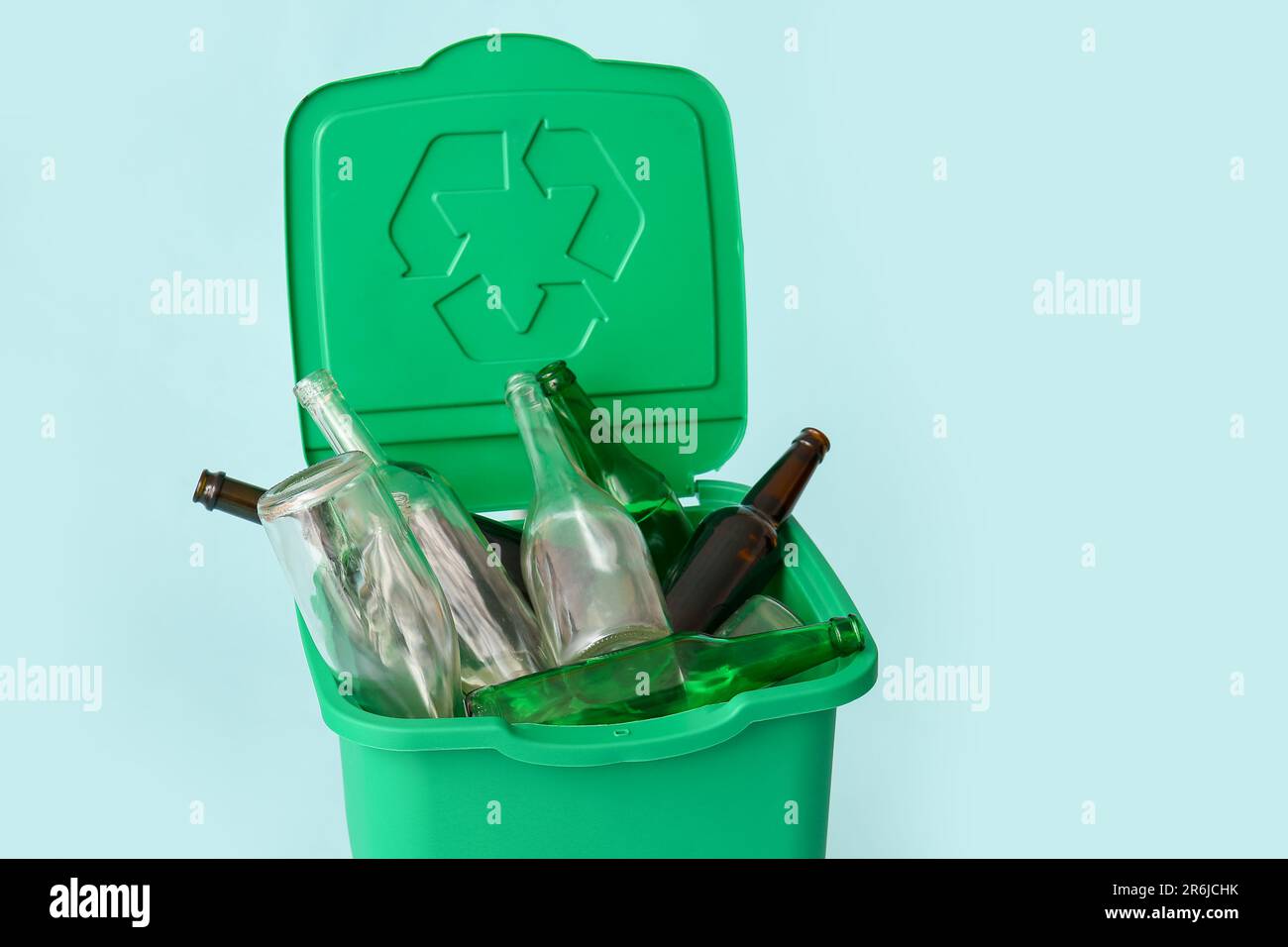 Container for garbage with glass bottles on light blue background ...