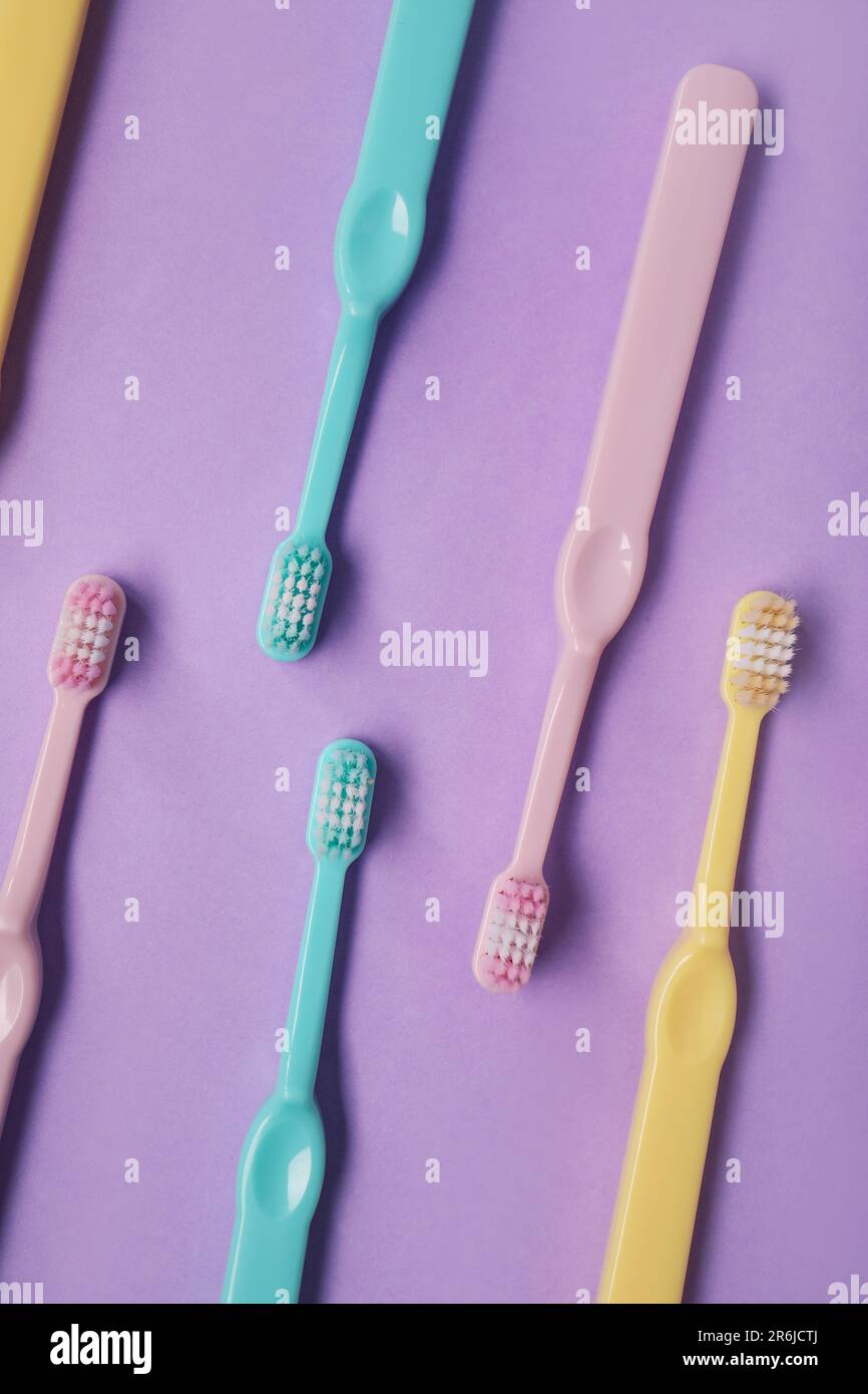 Many plastic toothbrushes on purple background Stock Photo - Alamy