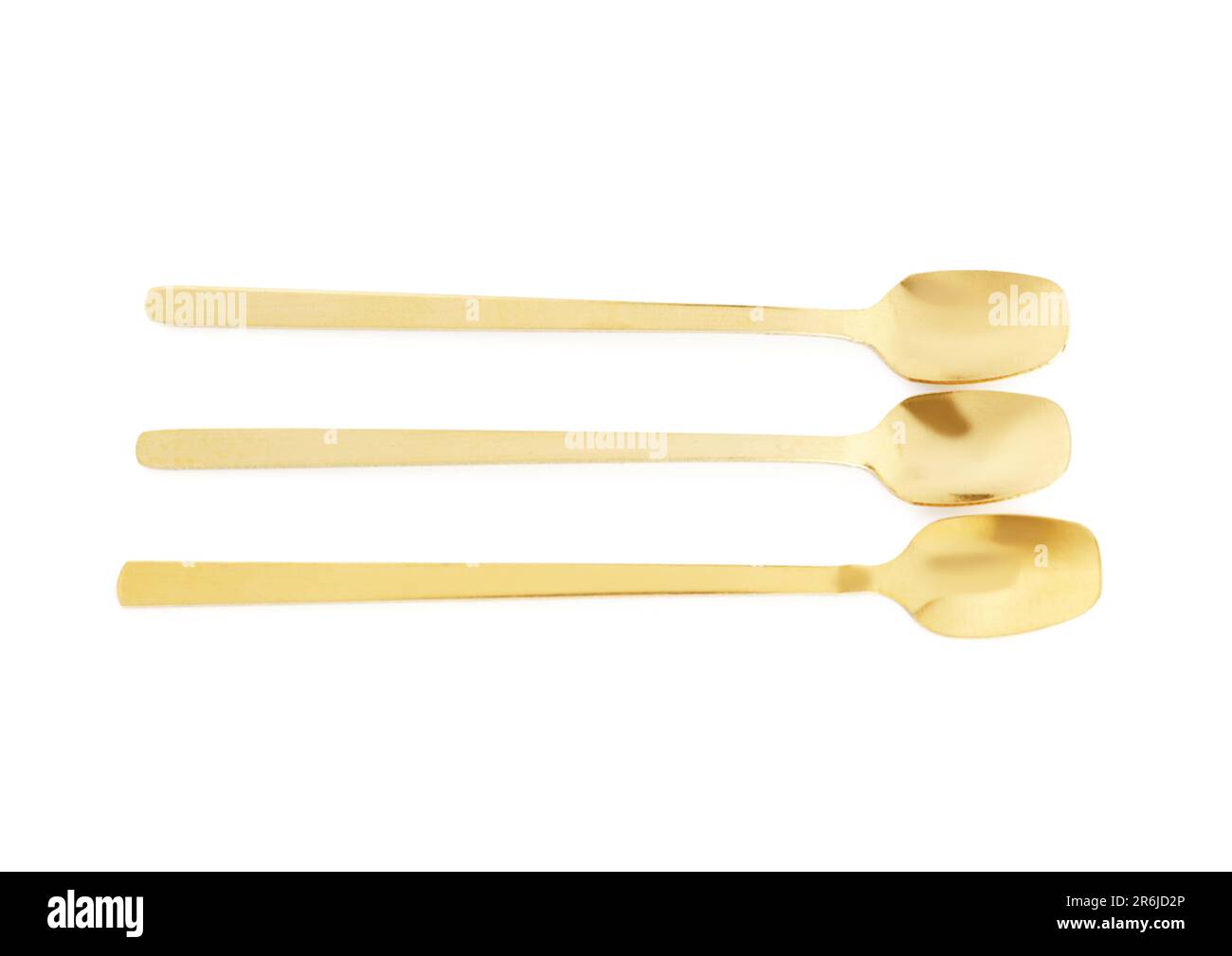 Golden spoons on white background Stock Photo - Alamy